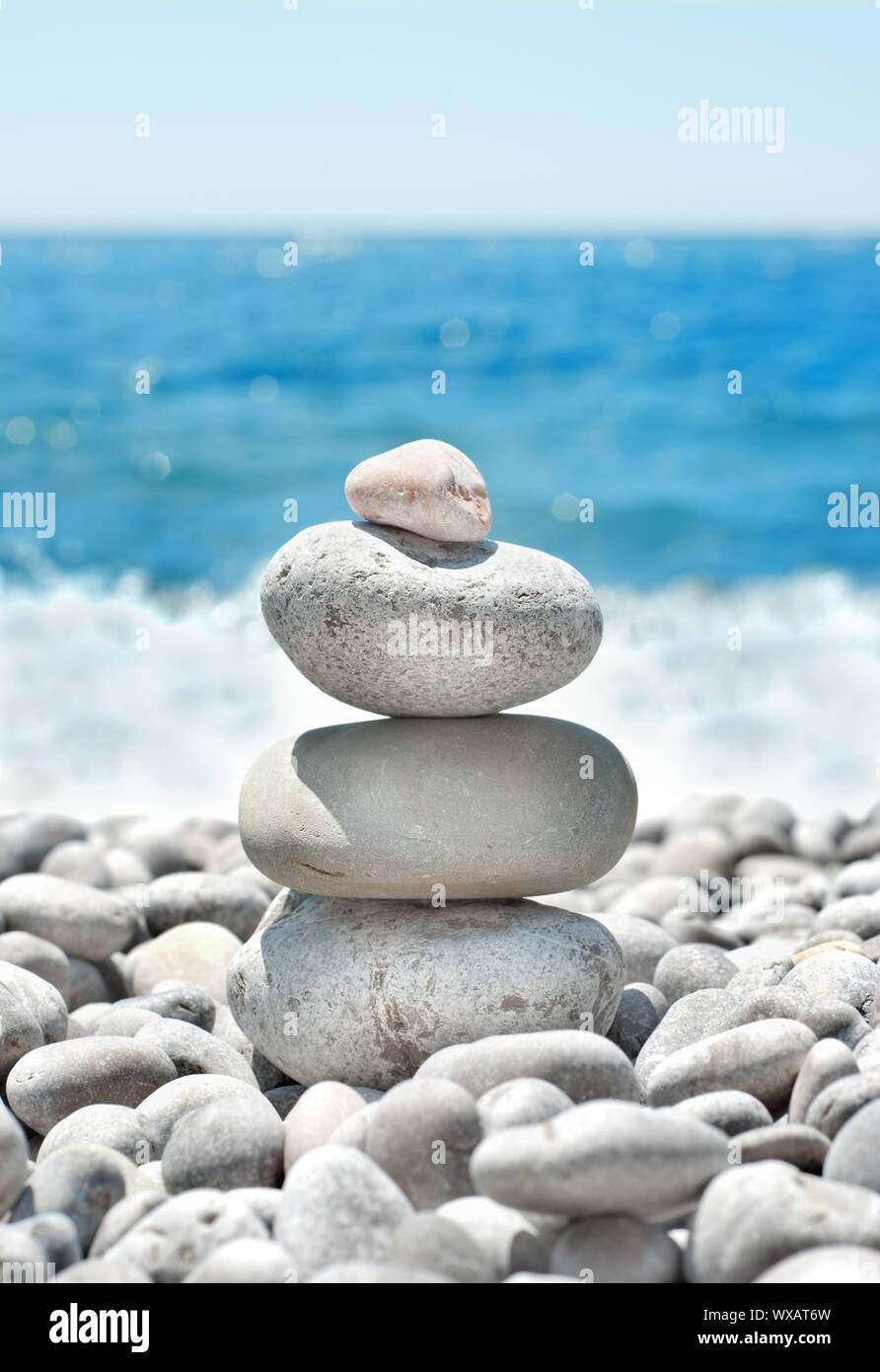 Stack sea pebbles against the blue sea Stock Photo - Alamy