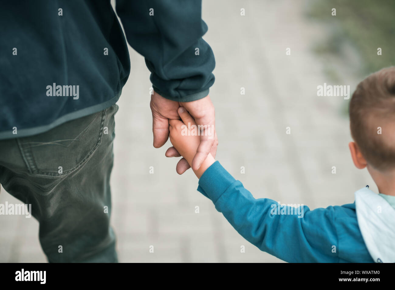 Little boy walking together with his father Stock Photo - Alamy