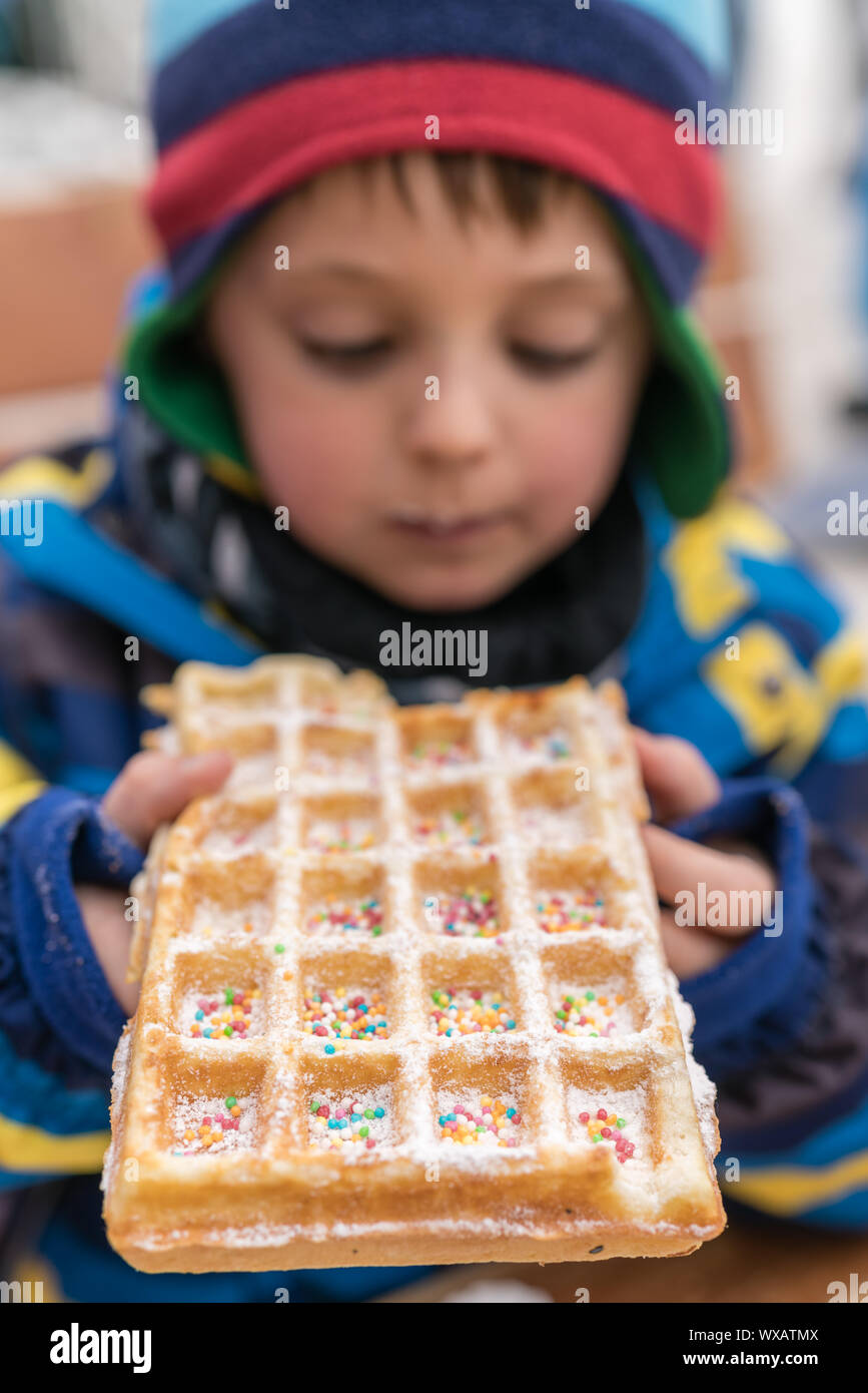 Little boy eating sweet waffle Stock Photo - Alamy