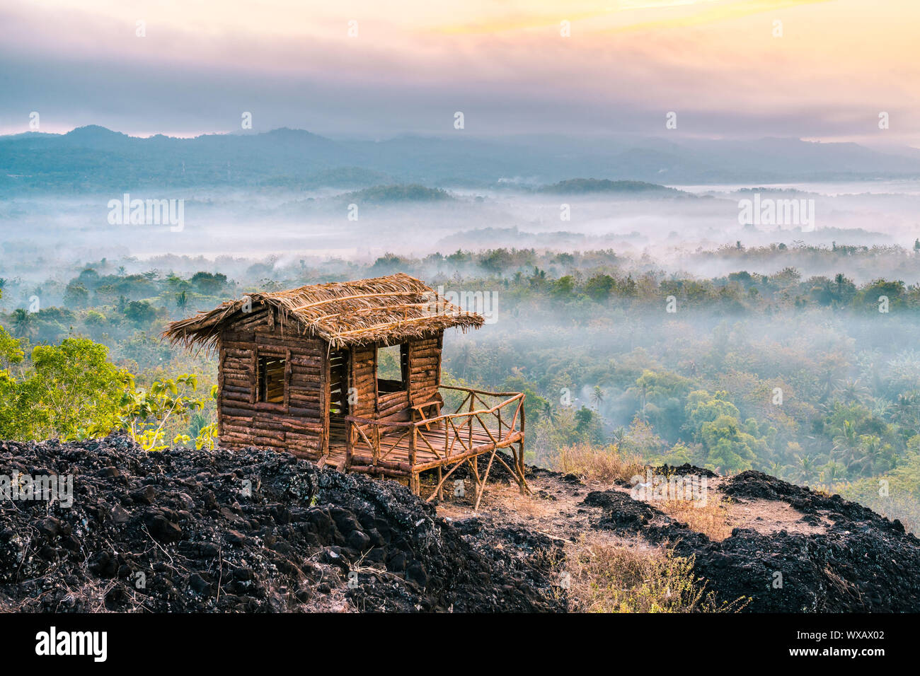 A wooden hut near a cliff with beautiful colorful sunrise scenery Stock ...