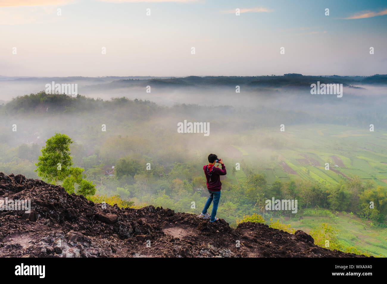 Tourists enjoying colorful sunrise with beautiful scenery and misty ...