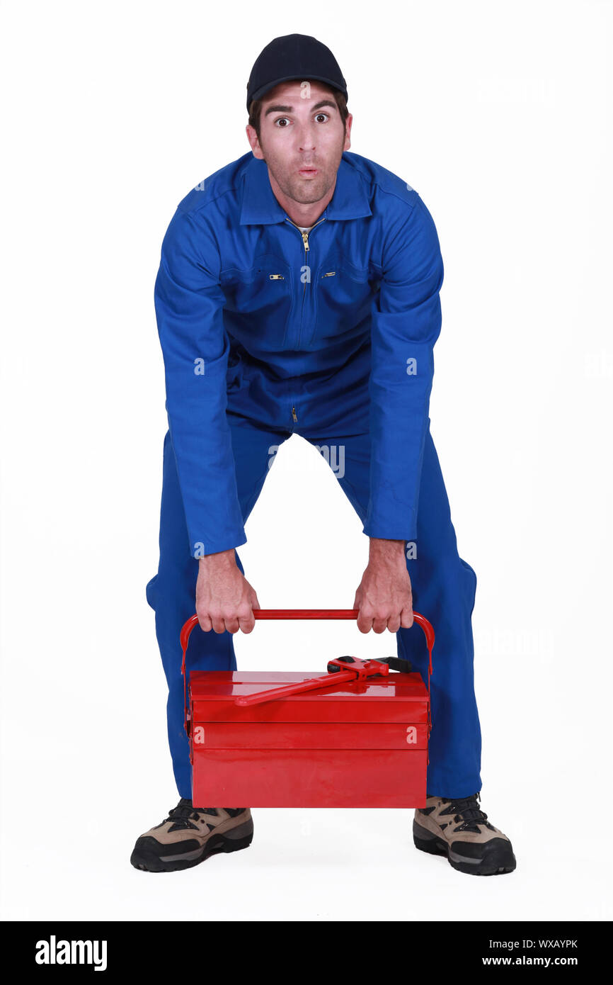 Man struggling to lift tool box Stock Photo - Alamy