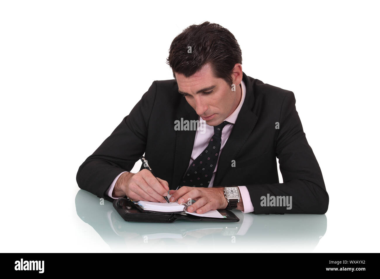 Man writing on a diary Stock Photo - Alamy