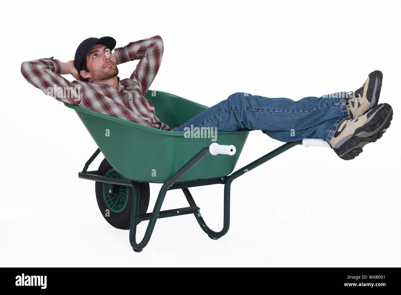 Laborer lying in a wheelbarrow Stock Photo - Alamy