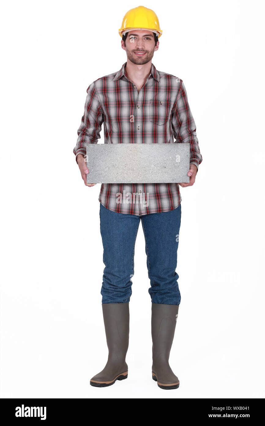 Many carrying breeze block Stock Photo - Alamy