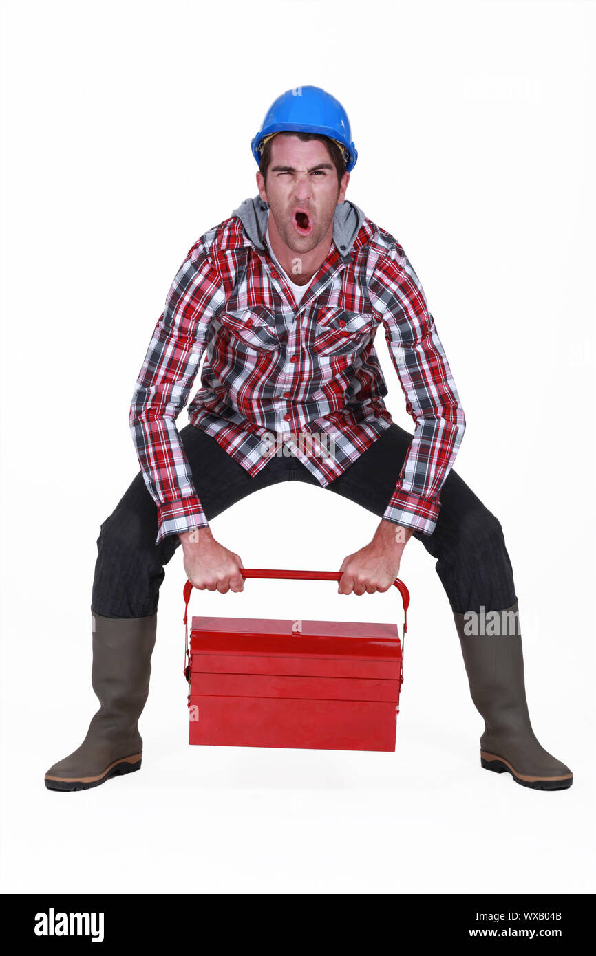 Worker struggling to lift tool box Stock Photo - Alamy