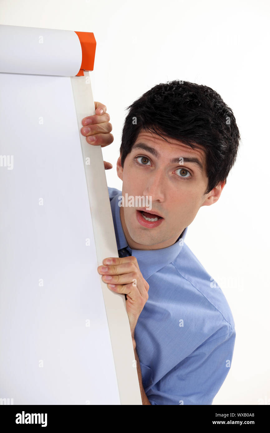 Uninspired man stood by blank flip-chart Stock Photo - Alamy