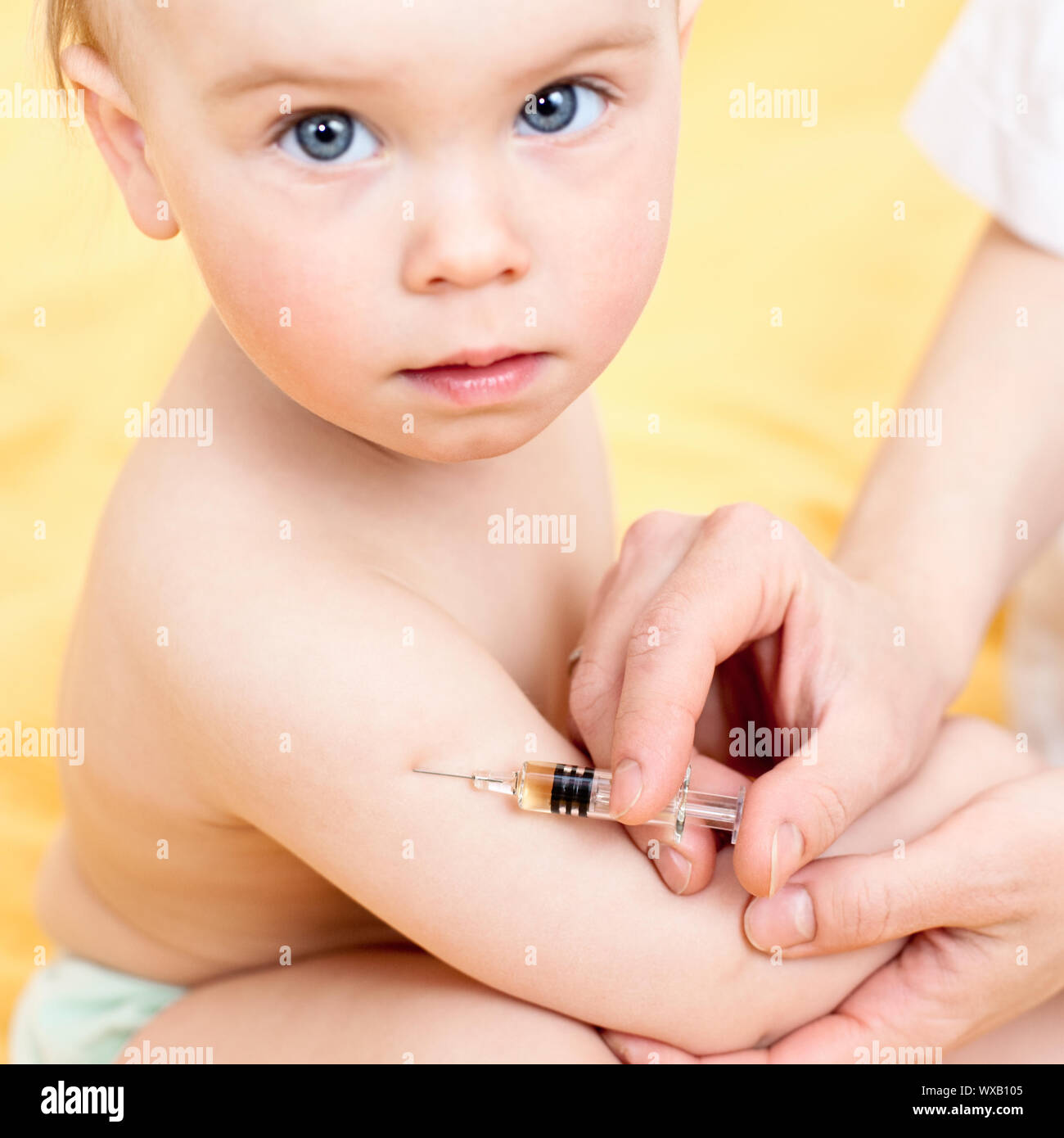 Doctor giving a child an intramuscular injection in arm, focus on ...