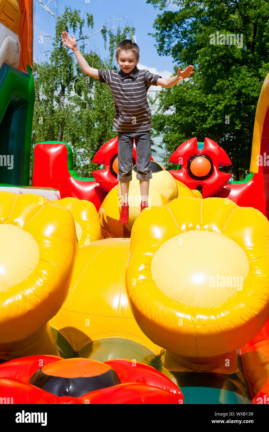 Young boy jumping on inflatable playground Stock Photo - Alamy