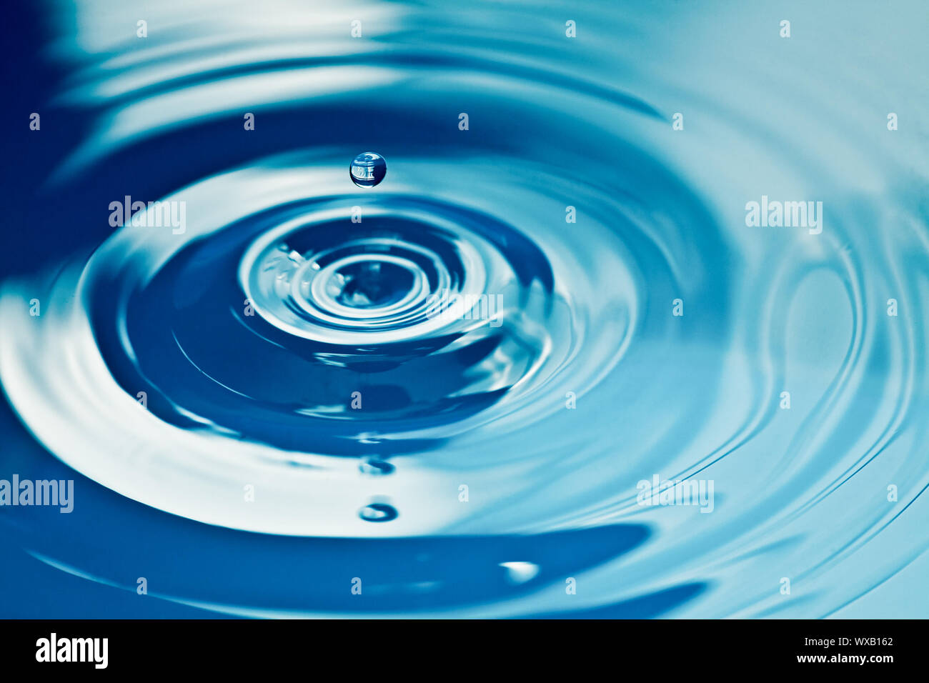 Water drop making a ripple on the surface Stock Photo - Alamy