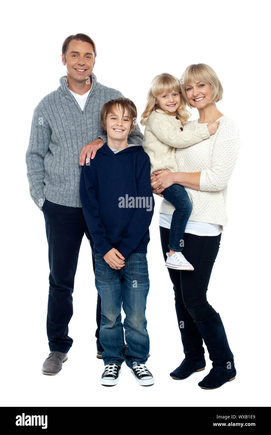 Full length portrait of a happy family posing in trendy winter wear ...