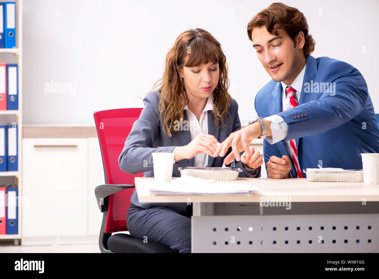 Two colleagues having lunch break at workplace Stock Photo - Alamy