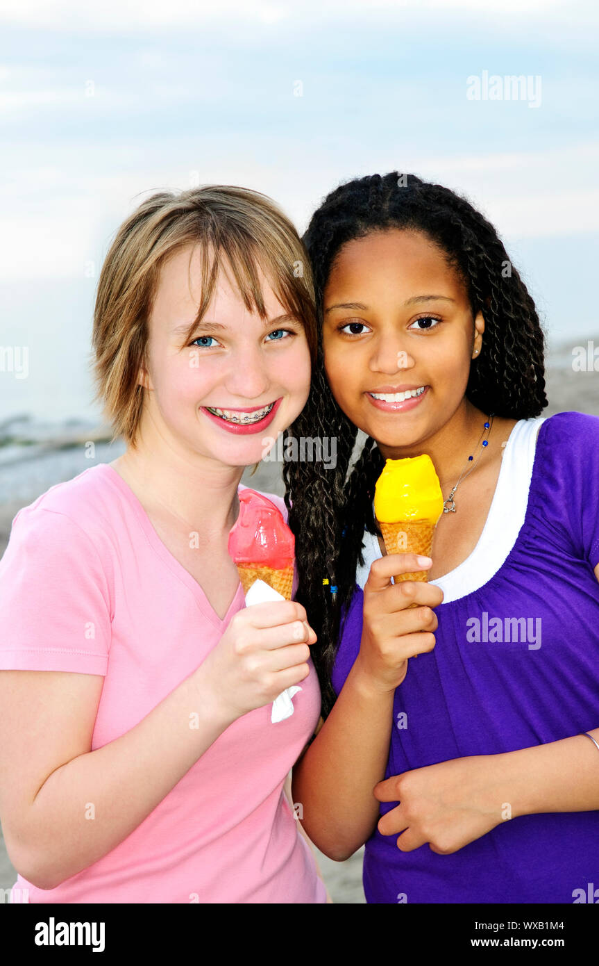 Portrait of two teenage girls eating ice cream cones Stock Photo - Alamy