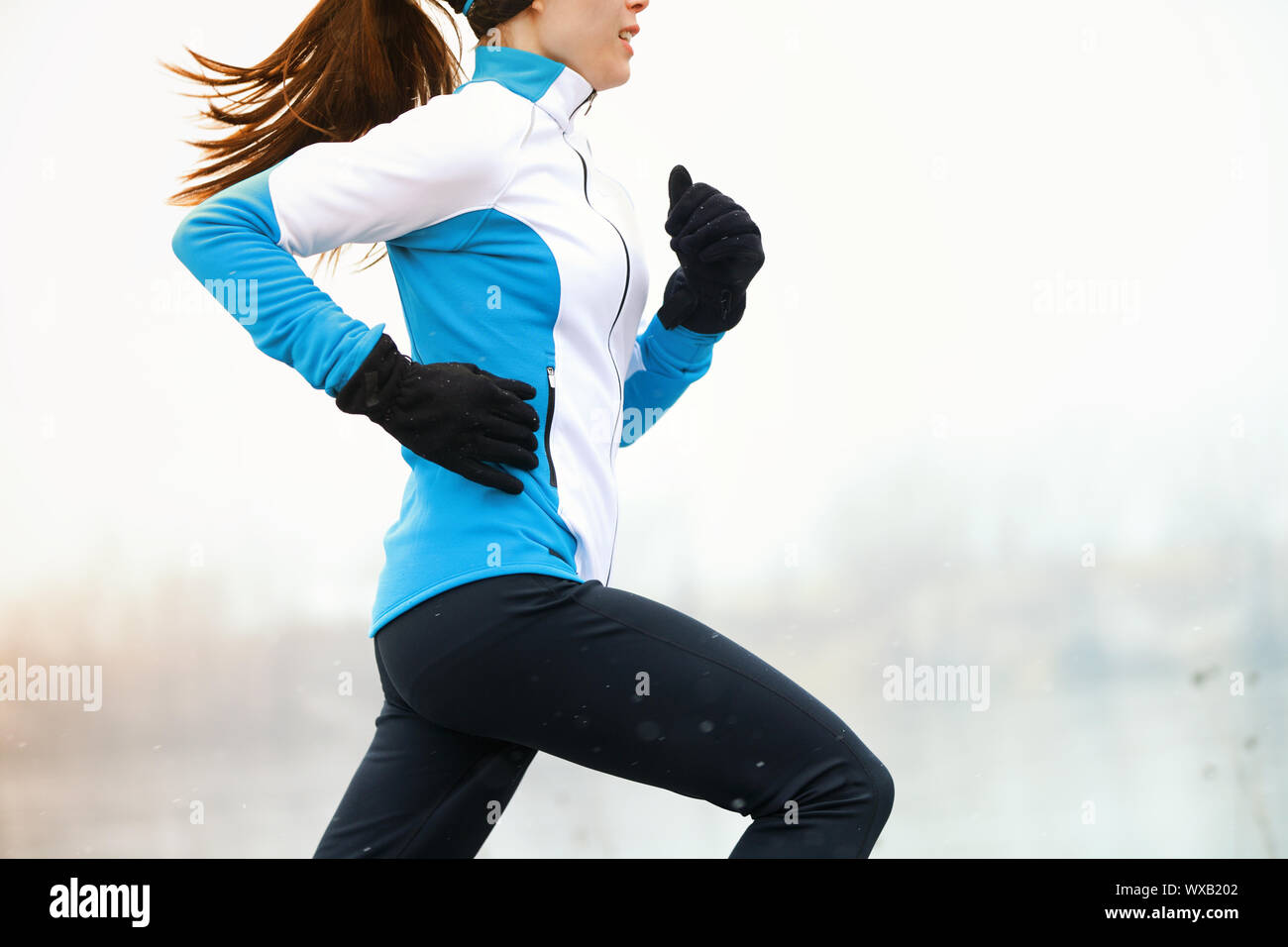 Running athlete woman sprinting during winter training outside in cold ...