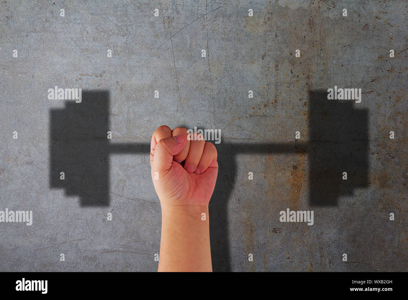 Strong and strength concept, hand and dumbbell shadow on concrete ...