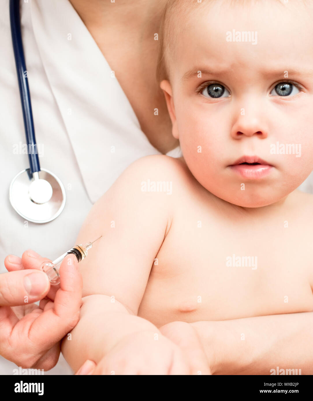 Doctor giving a child an intramuscular injection in arm, shallow DOF ...