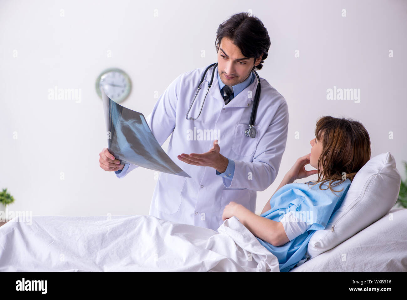 Male doctor visiting female patient in ward Stock Photo - Alamy