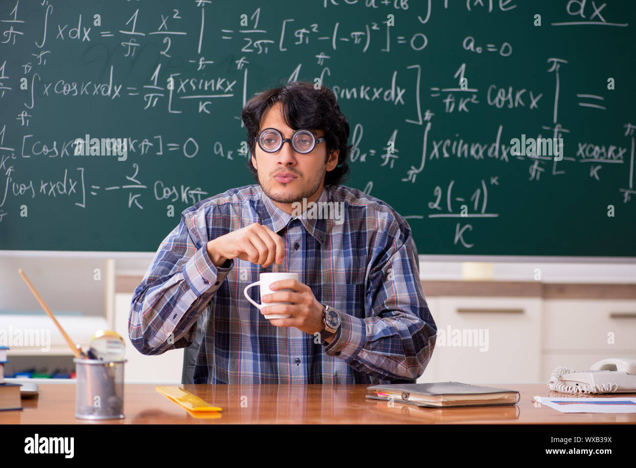 Funny male math teacher in the classroom Stock Photo - Alamy