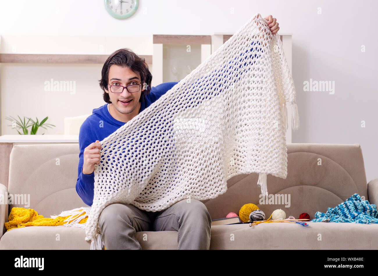 Young good looking man knitting at home Stock Photo - Alamy