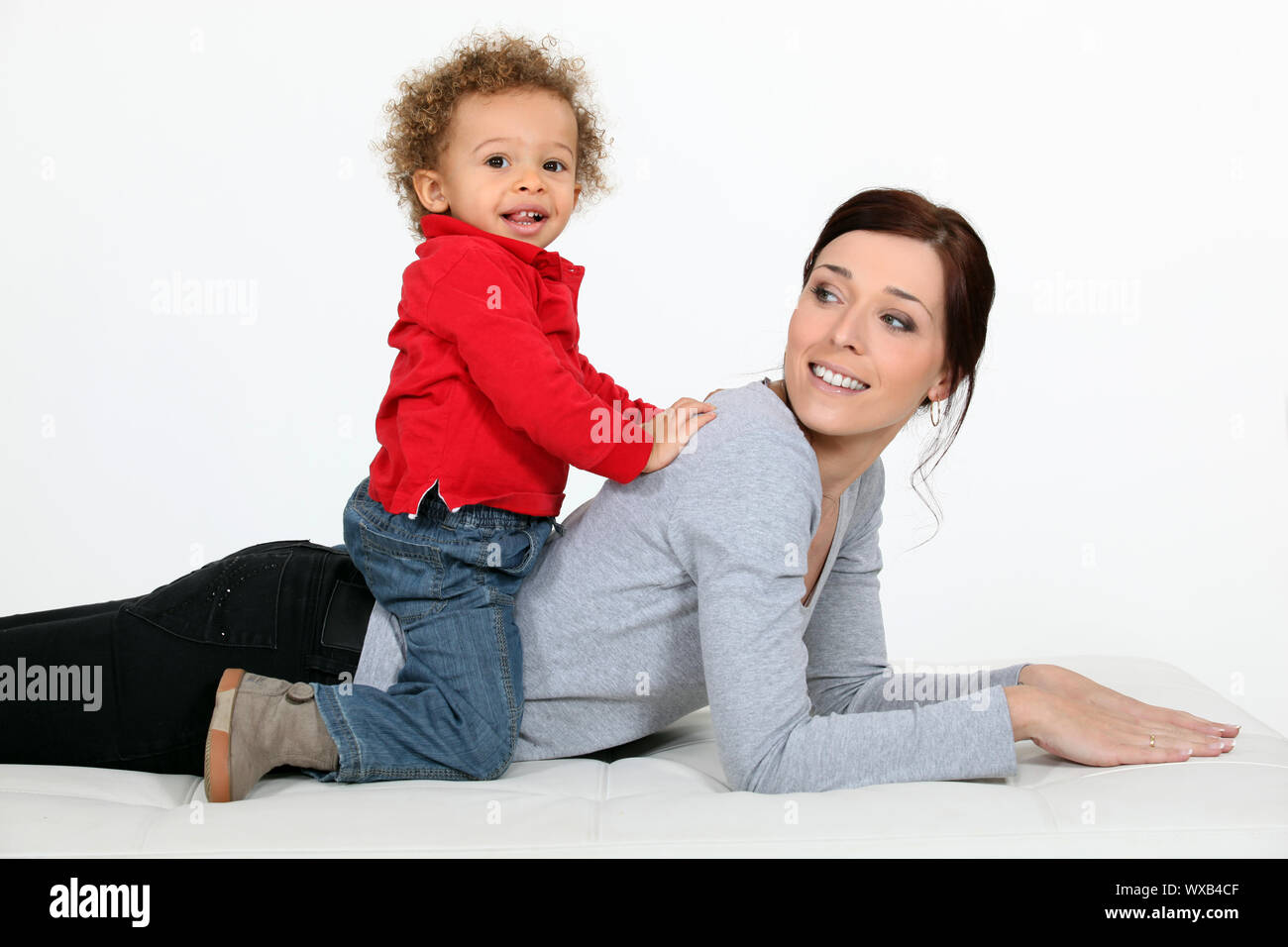 Little boy on his mother back Stock Photo - Alamy