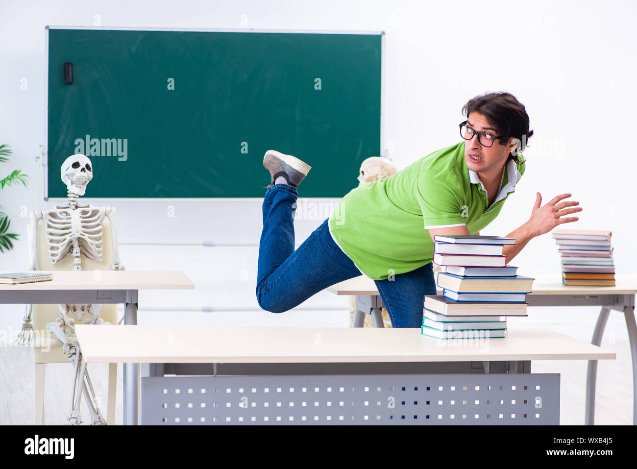 Funny male student in the classroom with skeleton Stock Photo - Alamy