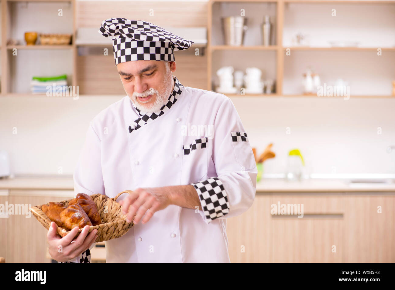 Old male baker working in the kitchen Stock Photo - Alamy