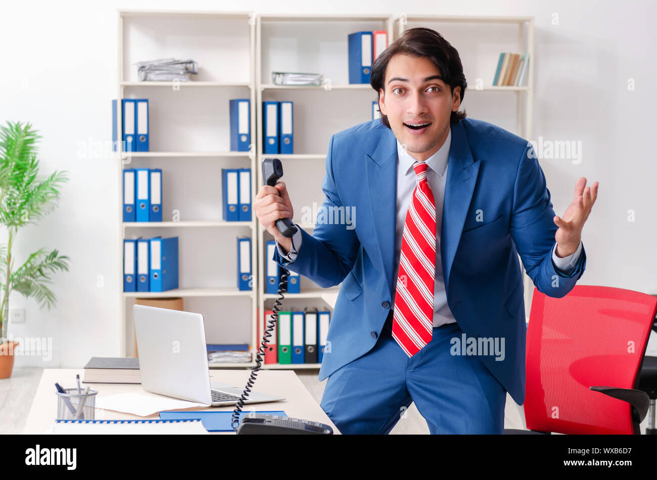 Young happy male employee in the office Stock Photo - Alamy