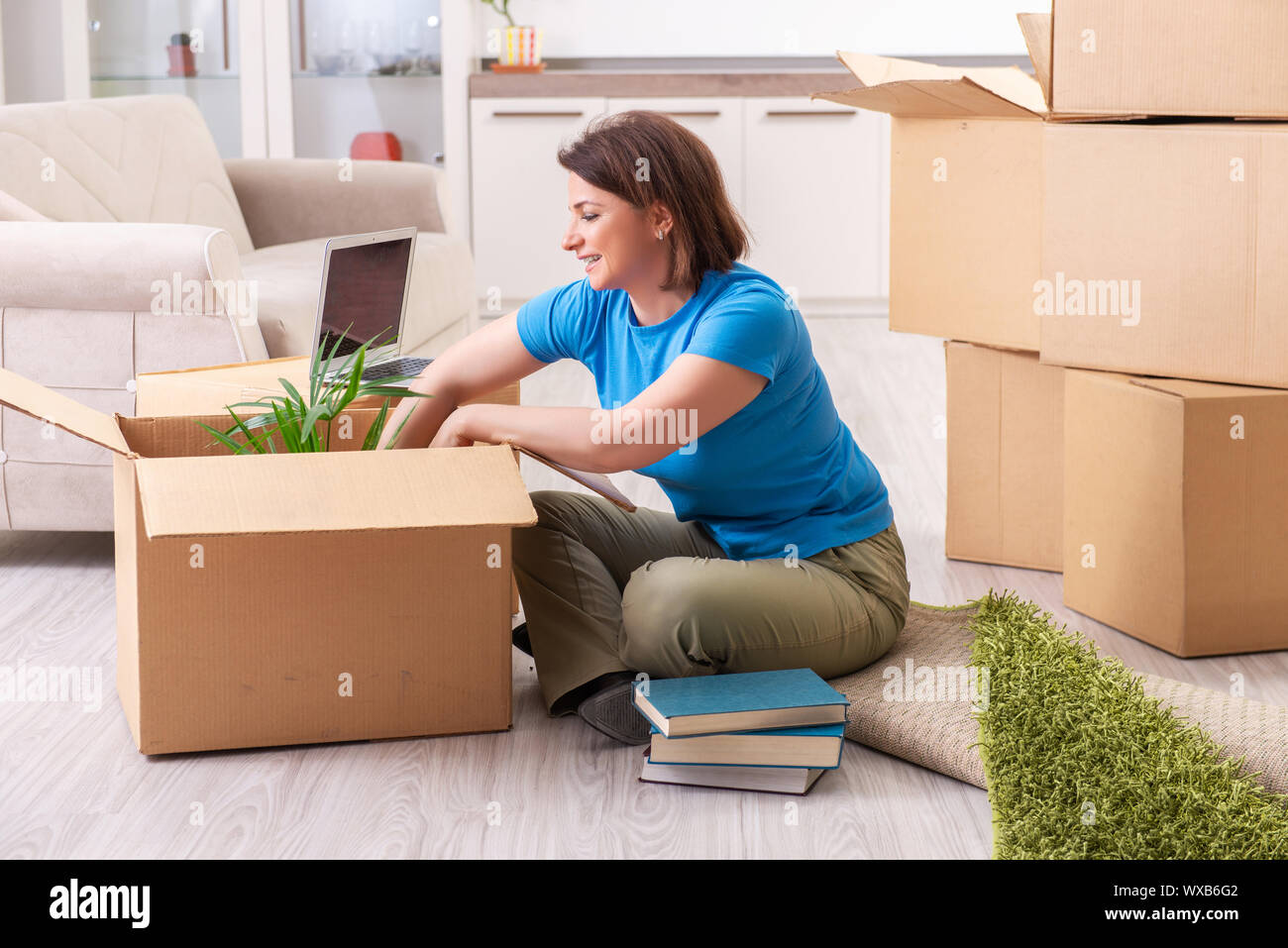 Middle-aged woman moving to new flat Stock Photo - Alamy