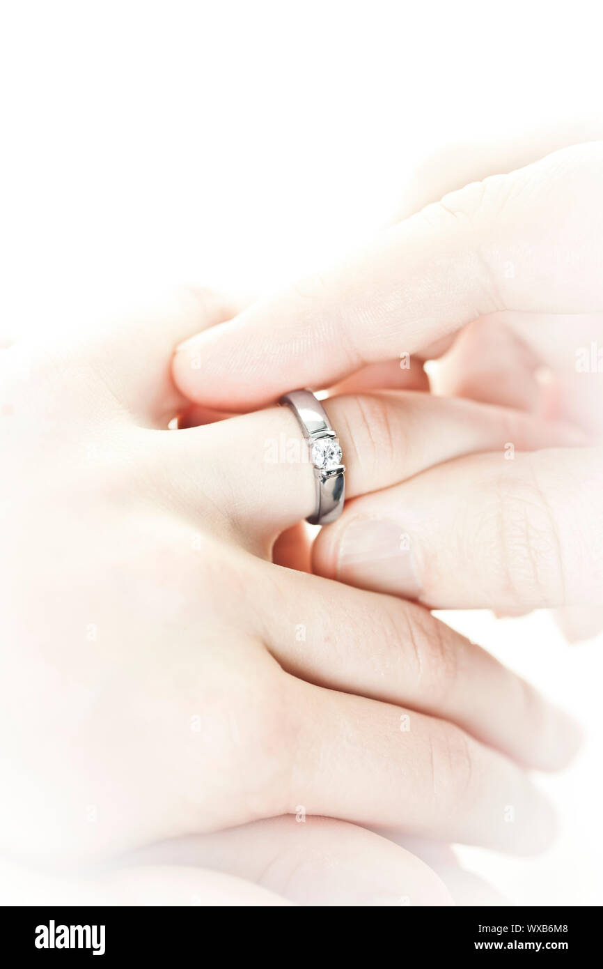 Closeup of hands placing engagement ring on finger Stock Photo - Alamy