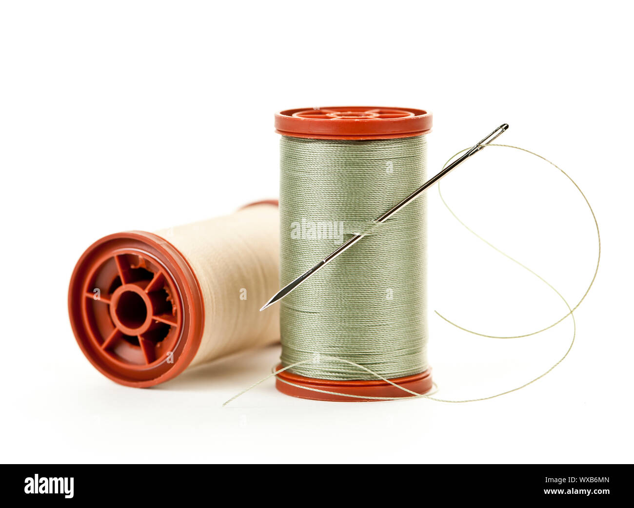Two spools of thread with needle for sewing isolated on white ...