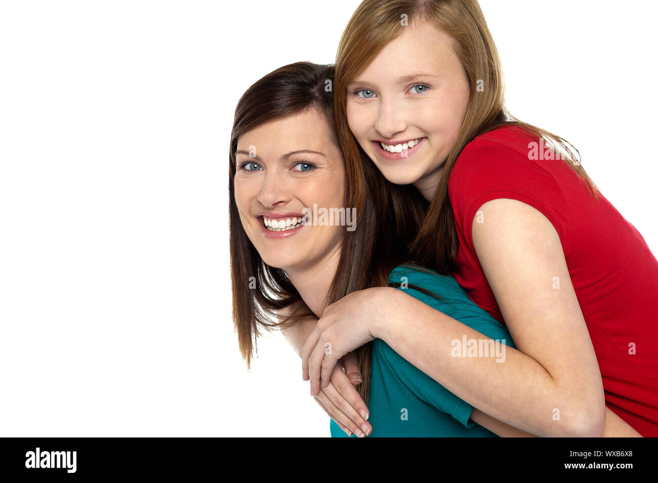 Mother giving daughter ride on back in studio Stock Photo - Alamy