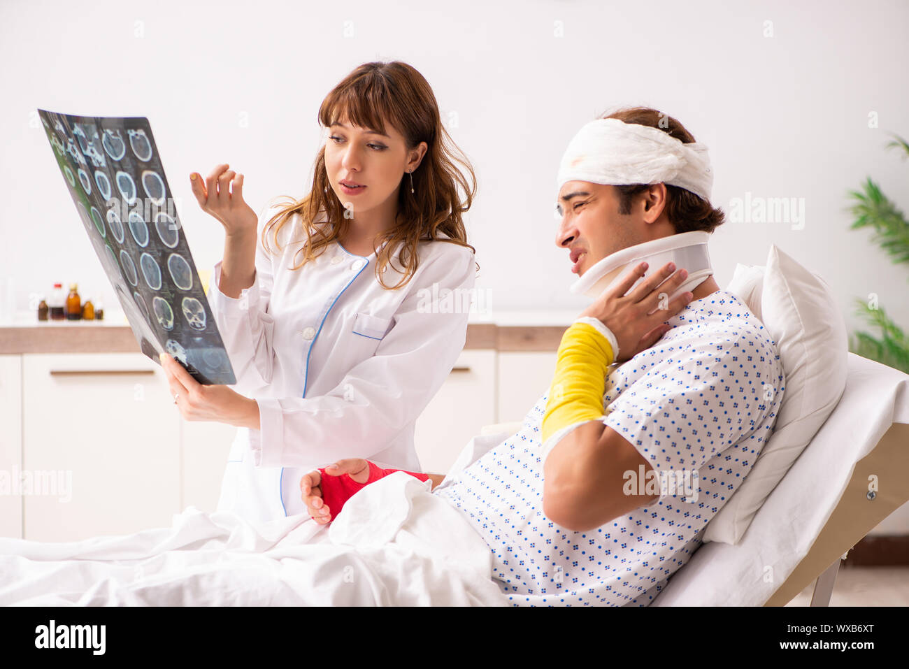 Young doctor examining injured patient Stock Photo - Alamy