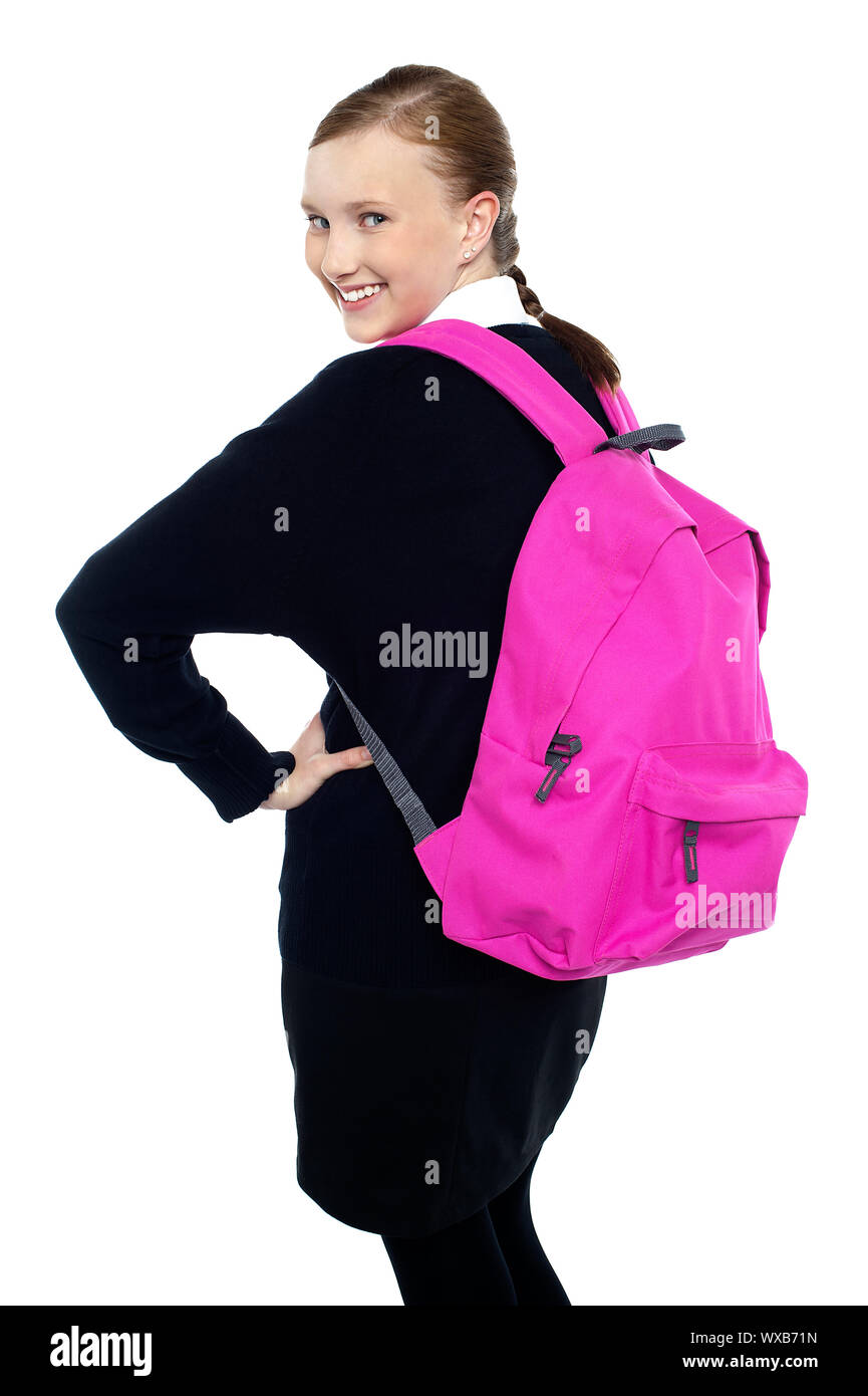 Charming teen girl with a pink backpack turning back and passing smile ...