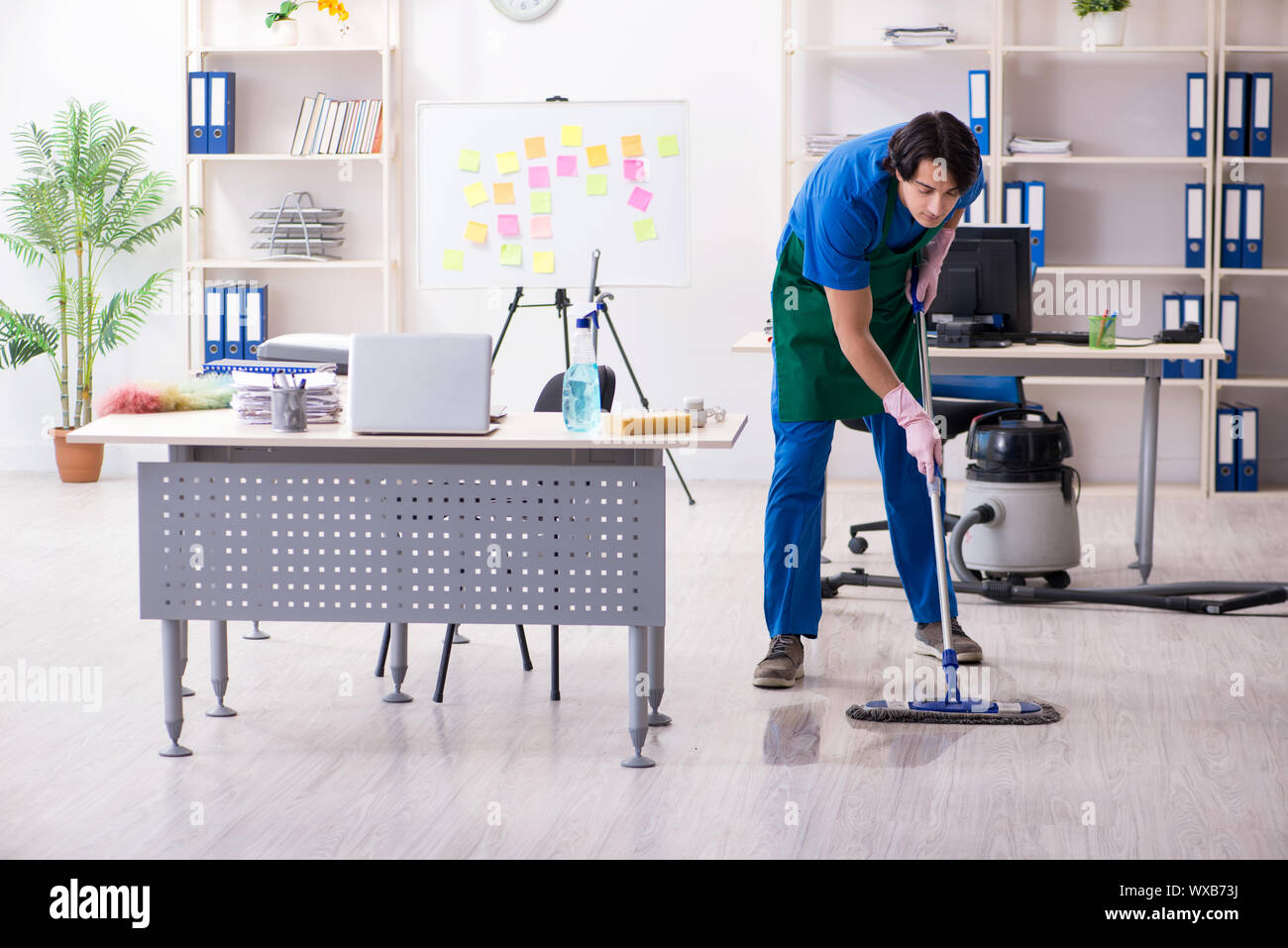 Male handsome professional cleaner working in the office Stock Photo ...