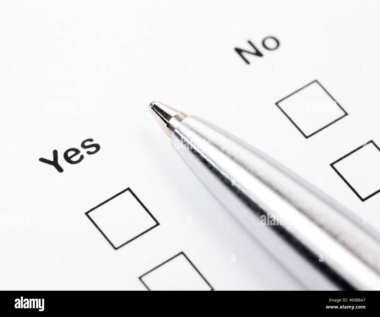 Close up shot of ballpoint between unfilled tick boxes Yes and No Stock ...
