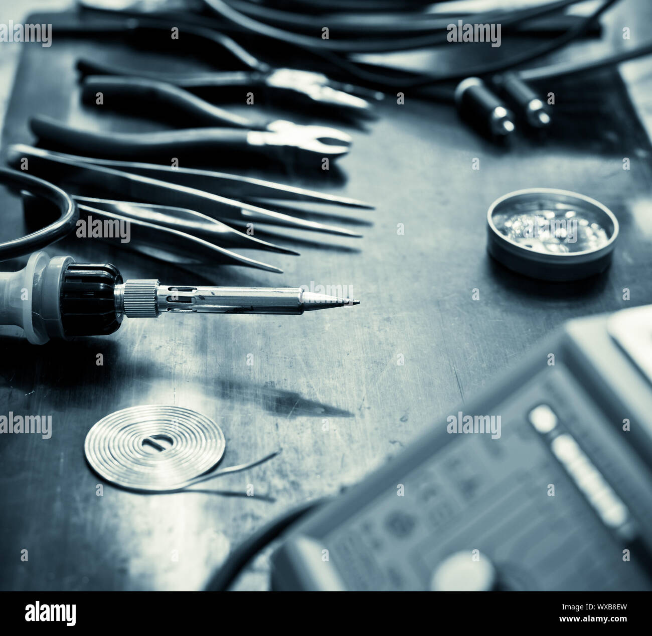 Soldering station with soft solder and tools in background, shallow DOF ...