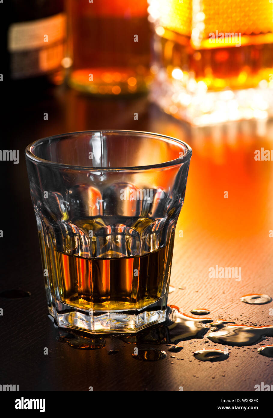 Glass of whiskey on table with drops, shallow DOF Stock Photo - Alamy