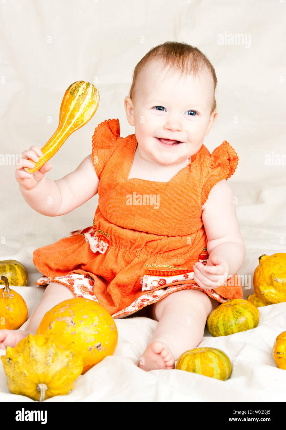 Little baby girl playing with calabash pumpkin Stock Photo - Alamy