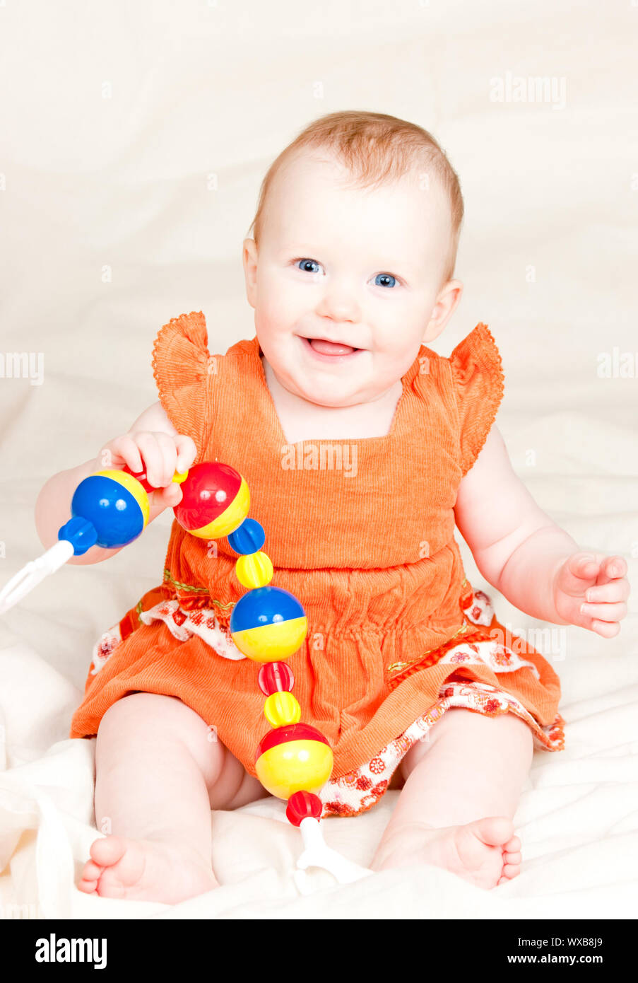Little baby girl playing with rattle Stock Photo - Alamy