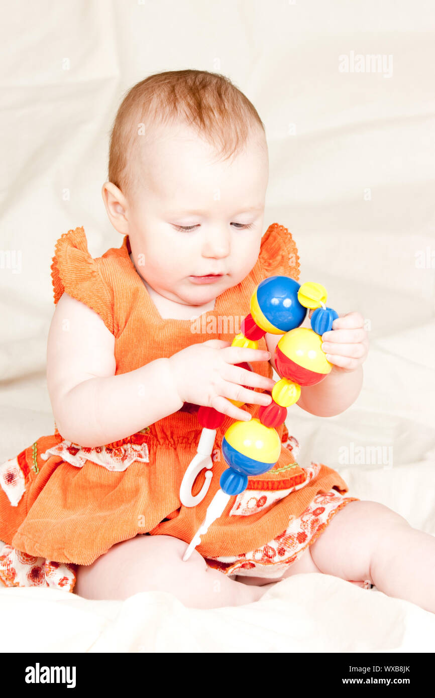 Little baby girl playing with rattle Stock Photo - Alamy