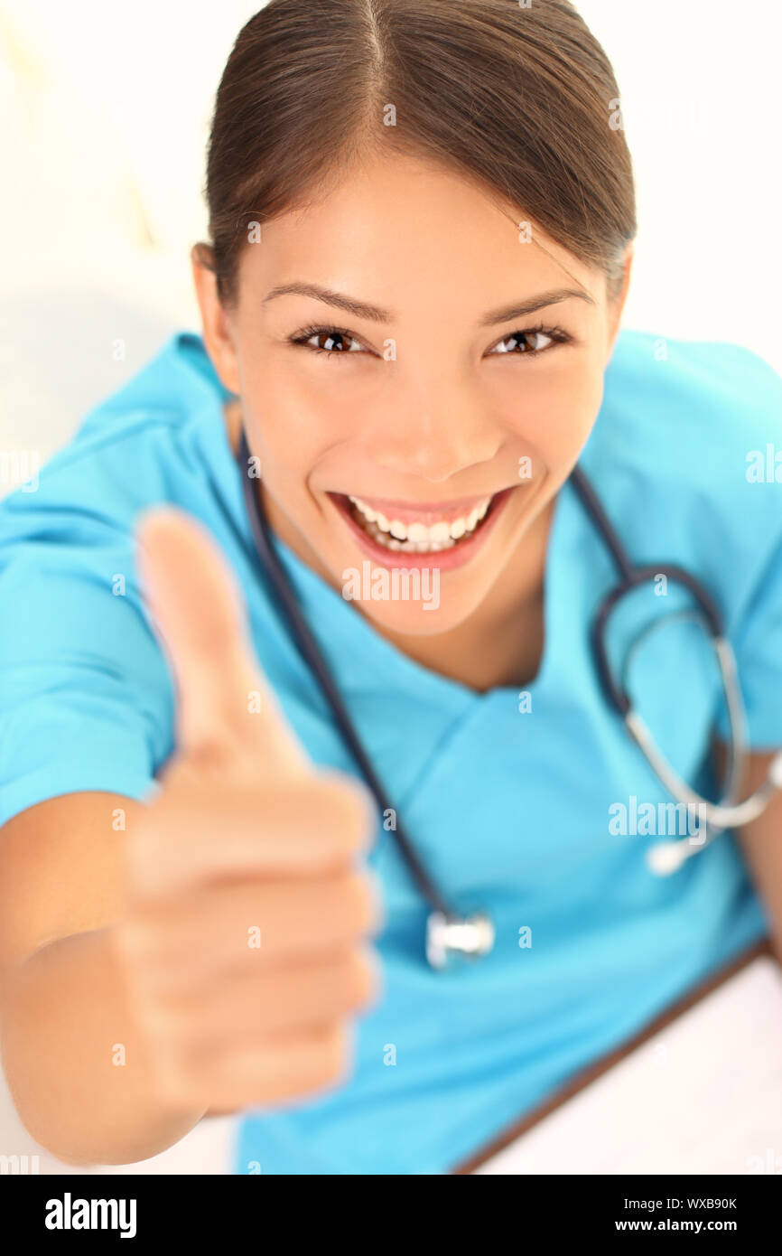Nurse happy thumbs up smile. Closeup high angle view portrait of young ...