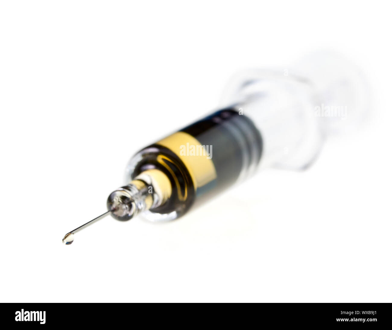 Medical syringe needle with yellow fluid on white background, very ...