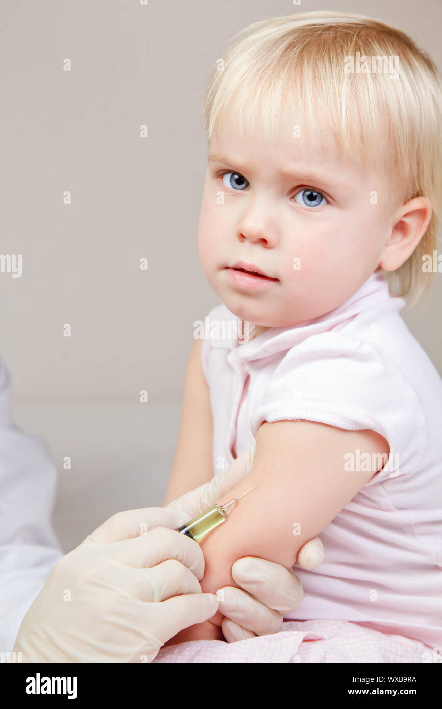 Doctor giving a child an intramuscular injection in arm Stock Photo - Alamy