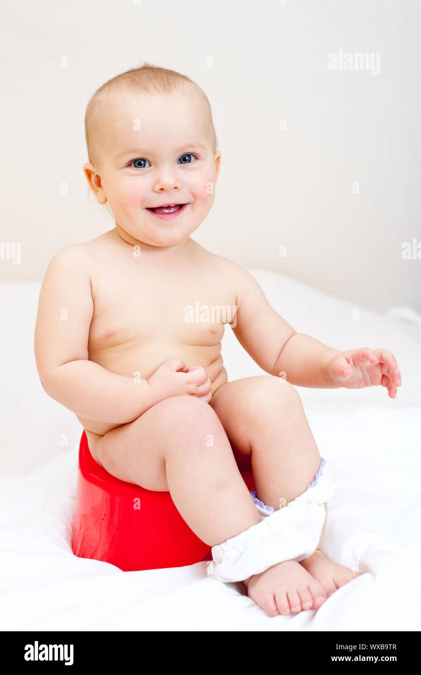 Cute little baby girl sitting on red potty Stock Photo - Alamy
