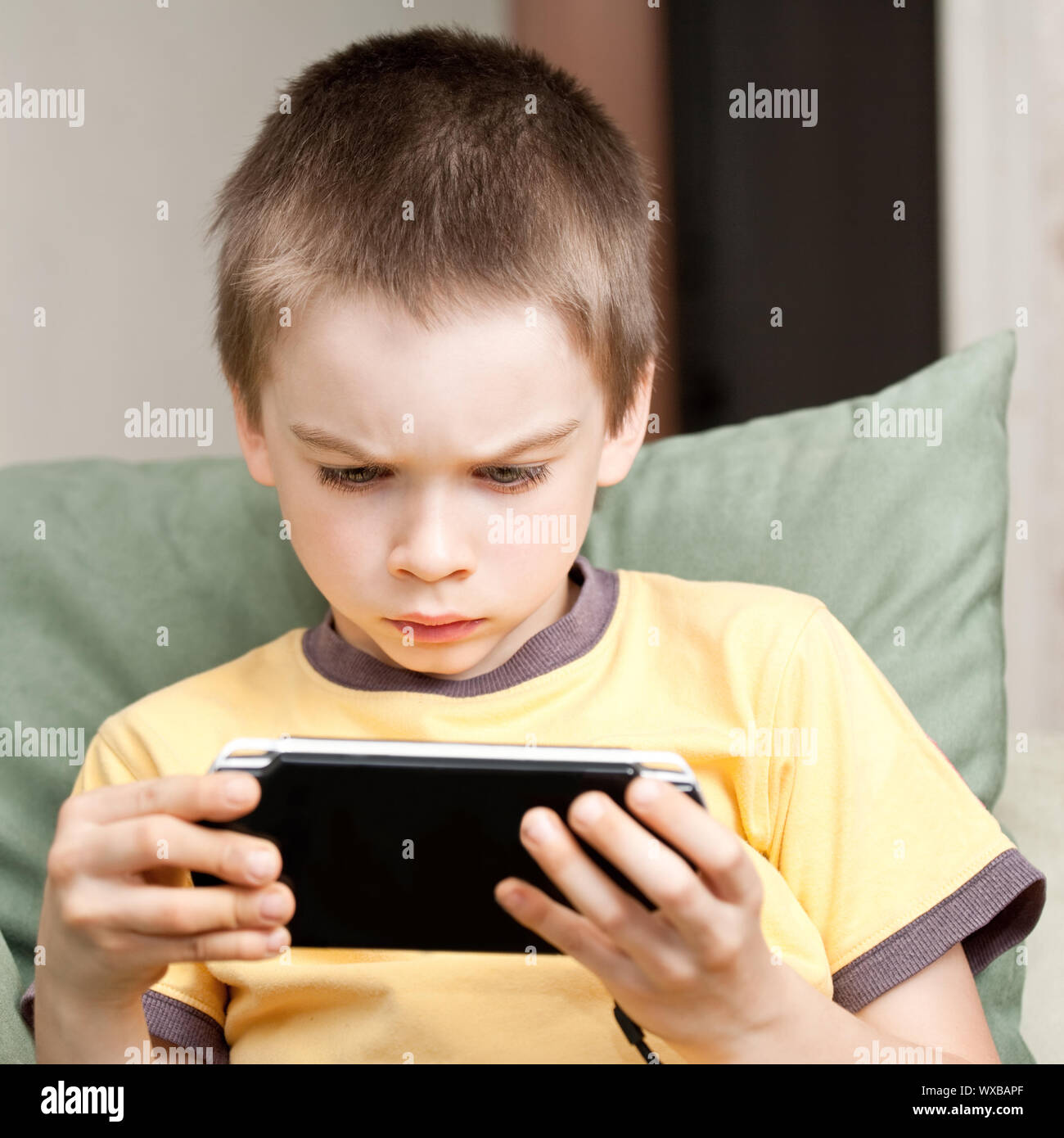 Young boy playing handheld game console Stock Photo - Alamy