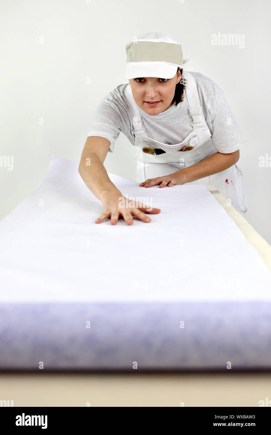 Woman paperhanger laying wallpaper Stock Photo - Alamy