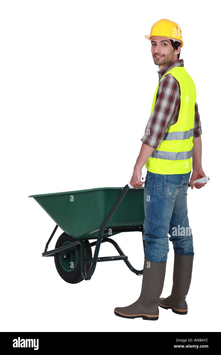 Man pushing wheelbarrow Stock Photo - Alamy