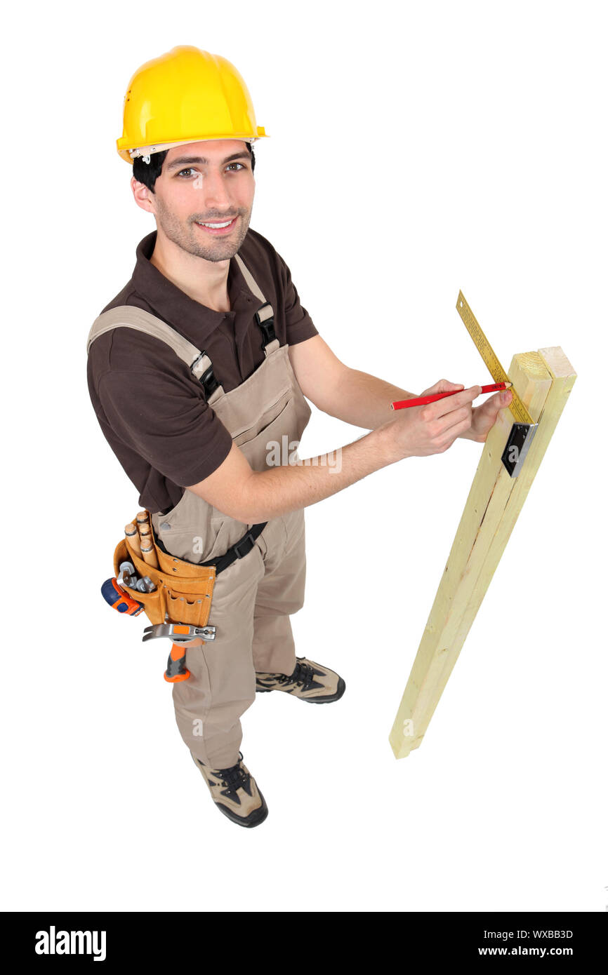Carpinter measuring plank of wood Stock Photo - Alamy