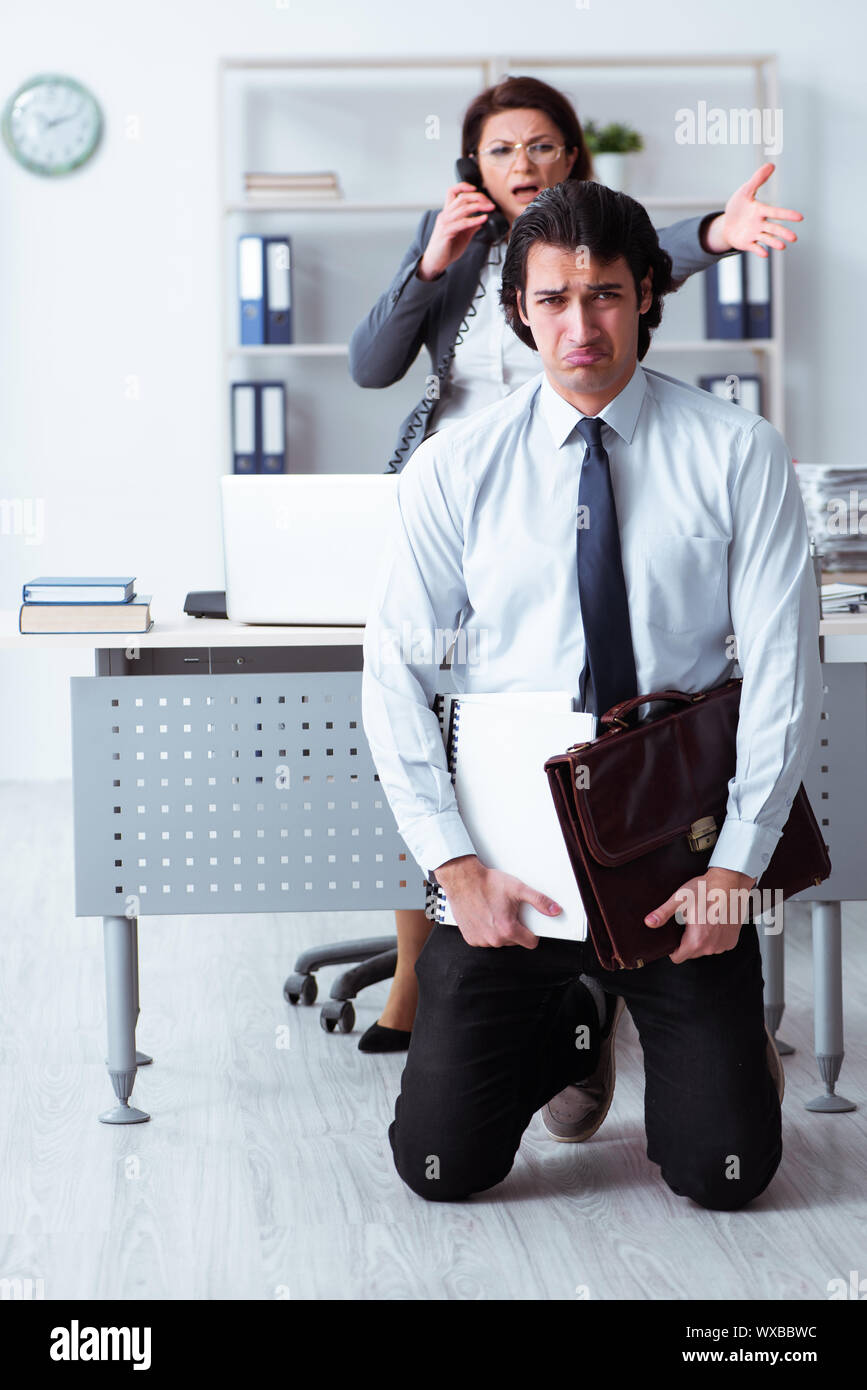 Old female boss and young male employee in the office Stock Photo - Alamy