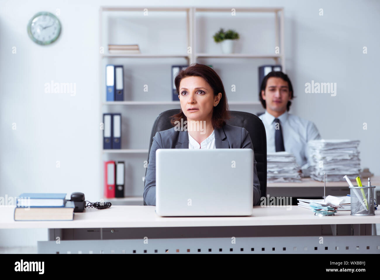 Old female boss and young male employee in the office Stock Photo - Alamy
